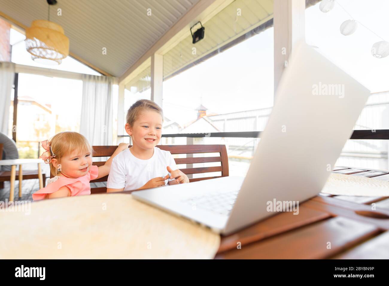 Small smiling kids brother and sister laugh and play laptop ...