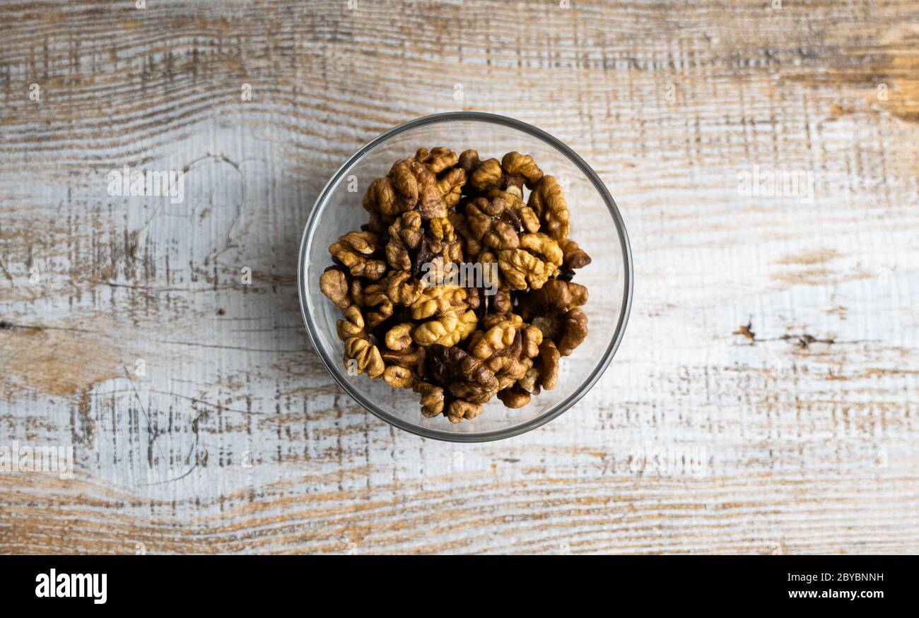 Walnut in a small plate on a vintage wooden table. Walnuts is a healthy ...