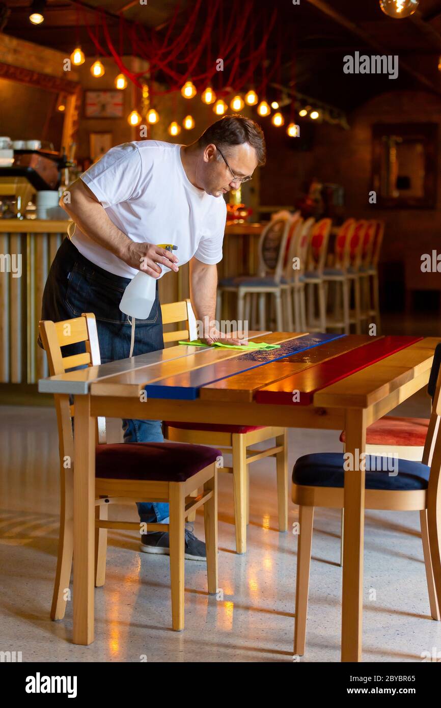 Waiter Cleaning the Table with Disinfectant Spray in a Restaurant Stock ...