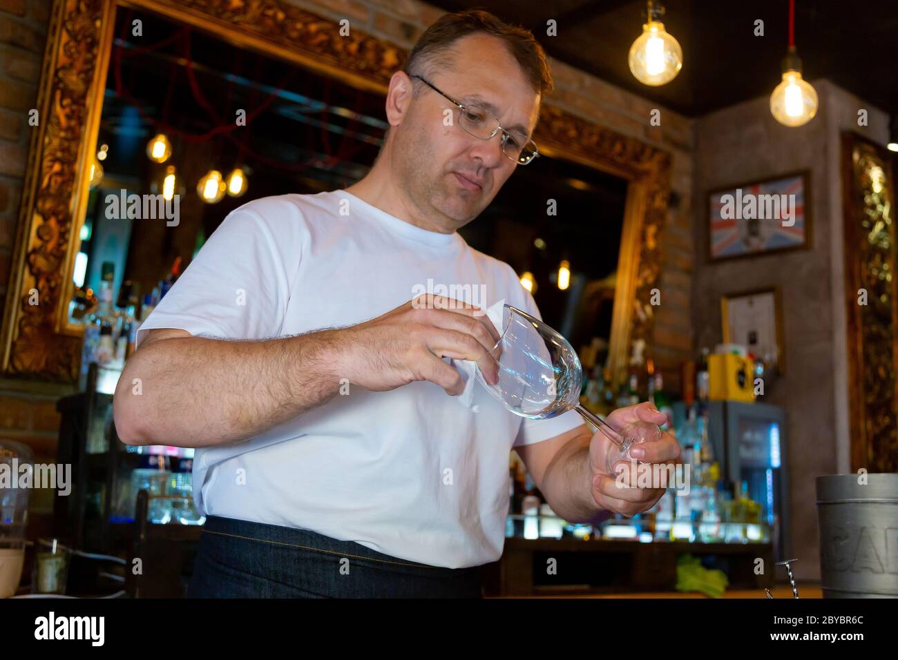 Bartender at the Bar Cleaning a Glass Stock Photo - Alamy