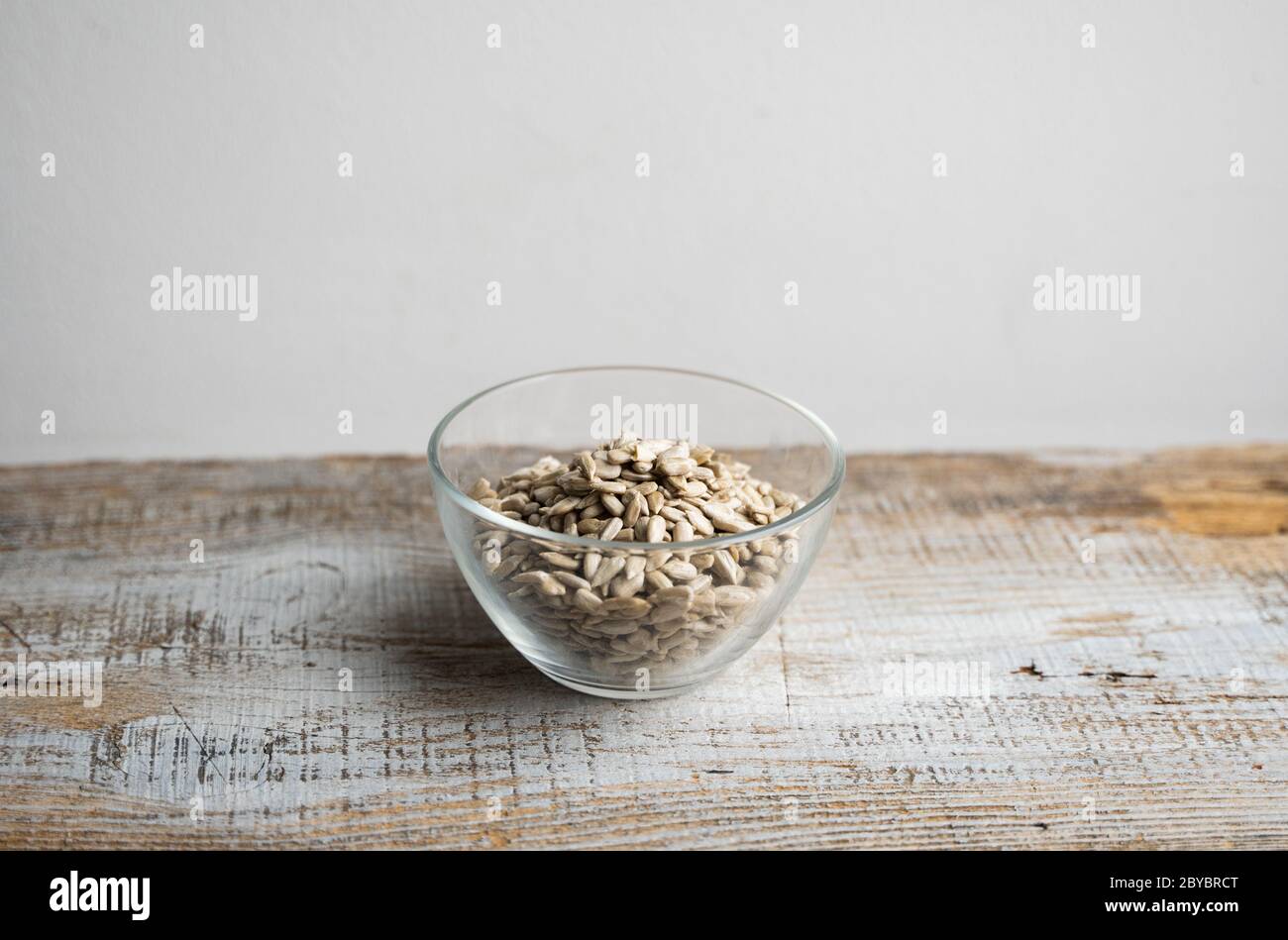 Sunflower seeds in a small plate on the wooden vintage table. Healthy ...