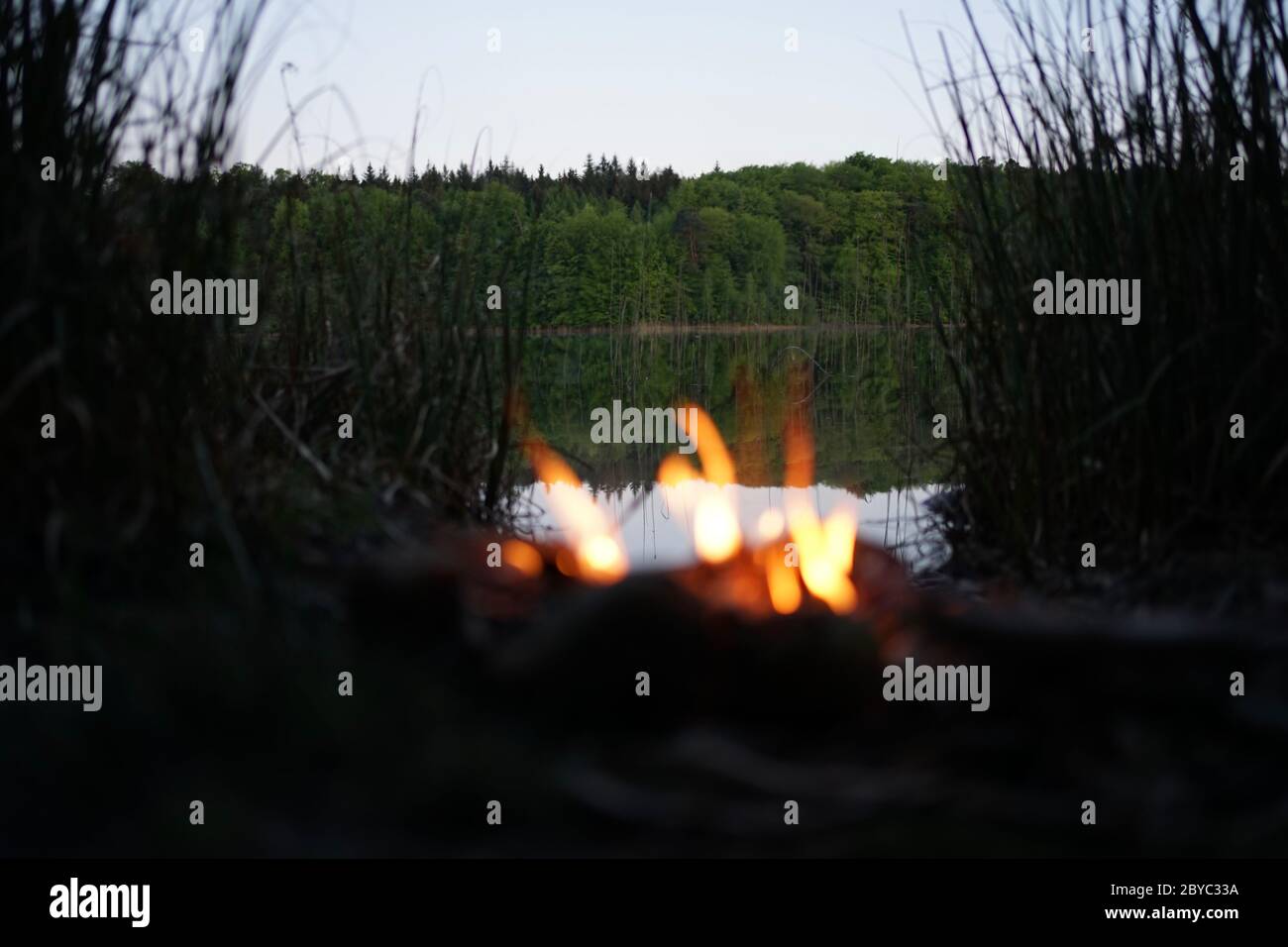 Bonfire at lake campsite at dusk Stock Photo - Alamy