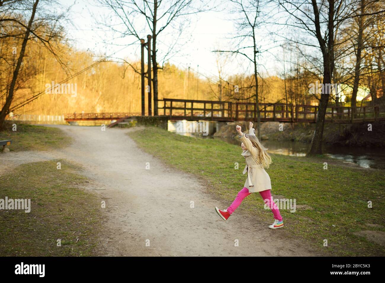Cute young girl having fun on beautiful sunny spring day. Active family ...