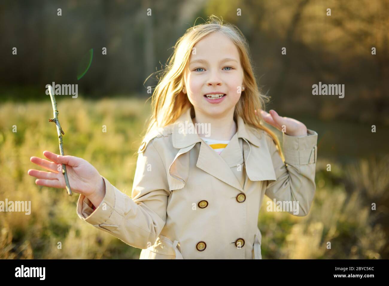 Cute young girl having fun on beautiful sunny spring day. Active family ...