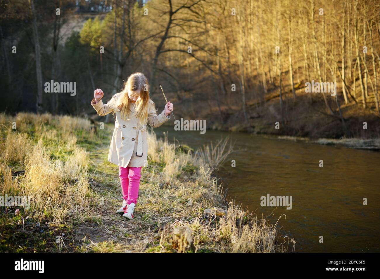Cute young girl having fun on beautiful sunny spring day. Active family ...
