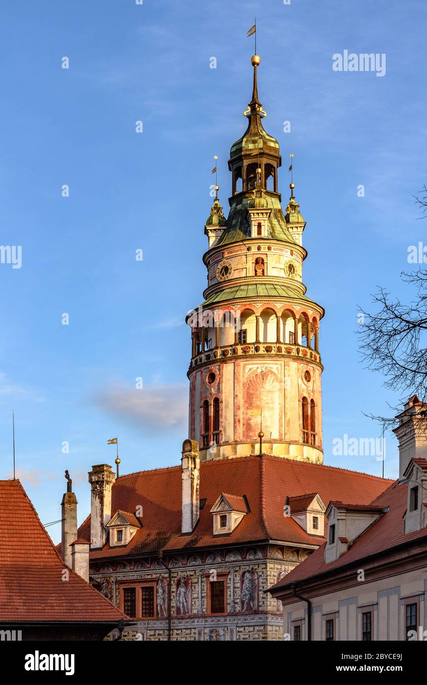 The illuminated baroque tower of Cesky Krumlov castle at golden hour ...