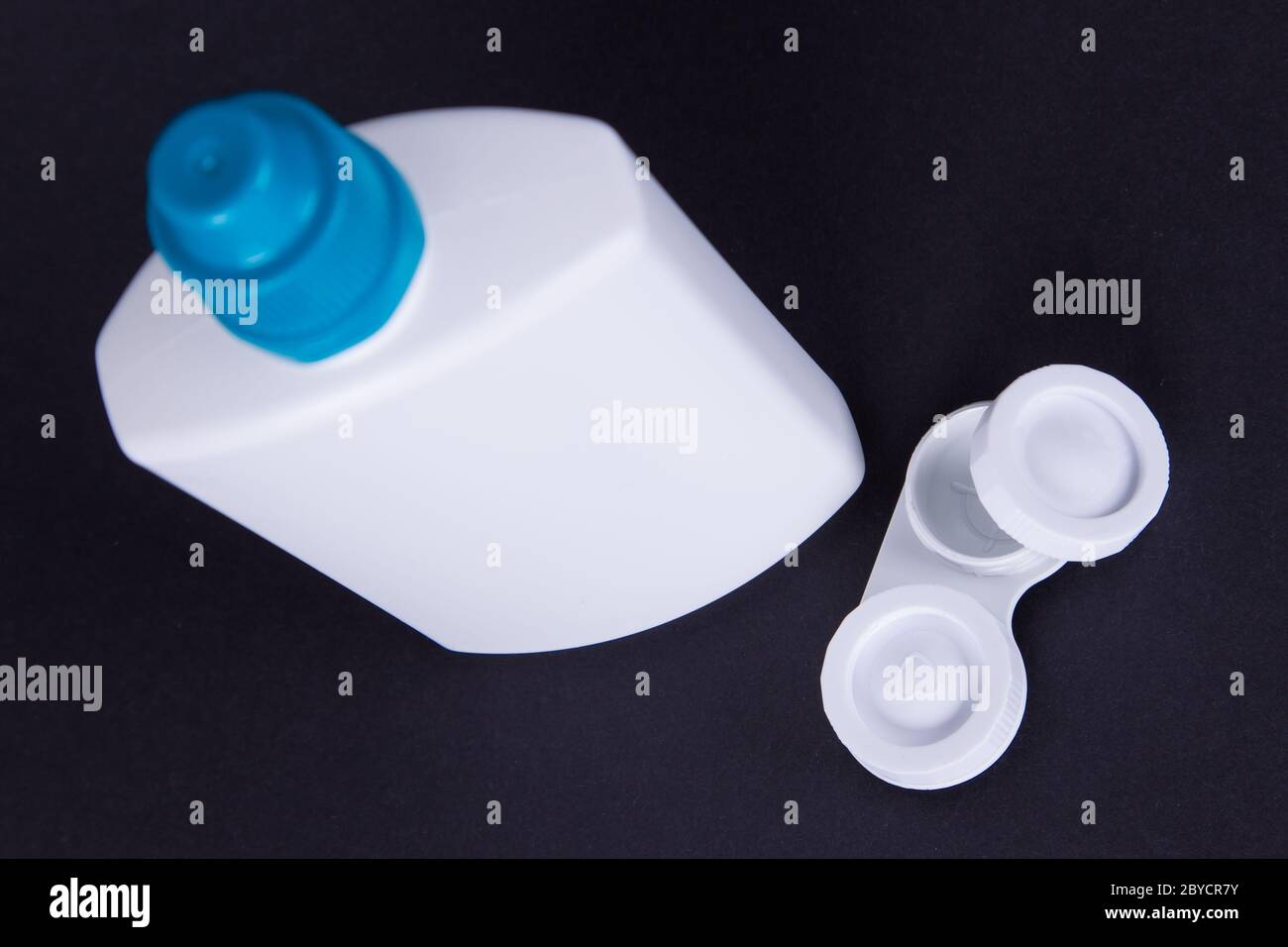Lens casing and bottle of water isolated on black Stock Photo - Alamy