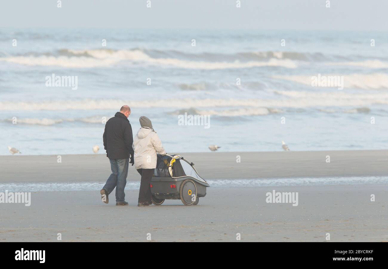 Rear view of a young couple, with the female pushing a pram Stock Photo ...