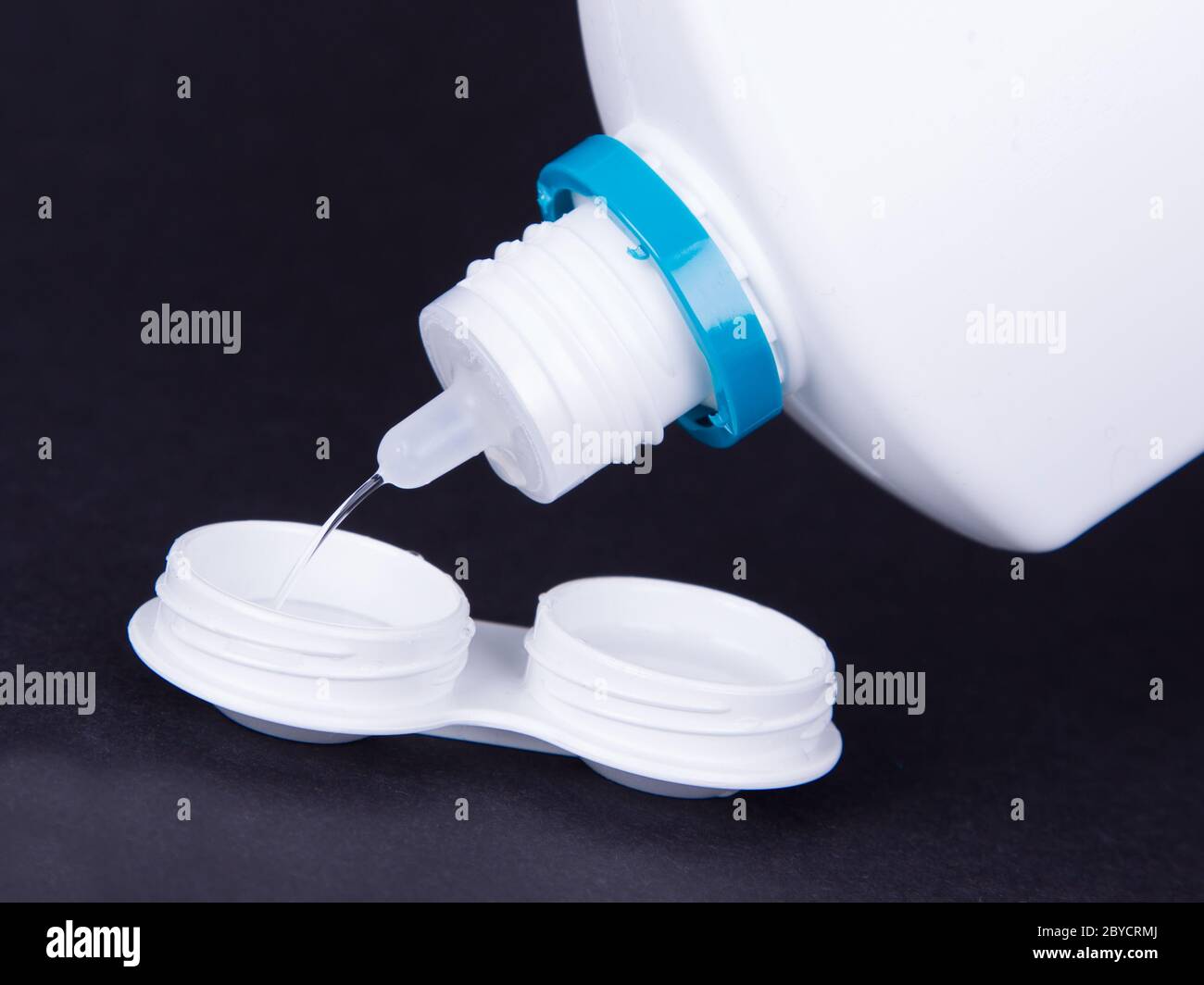 Lens casing and bottle of water isolated on black Stock Photo - Alamy