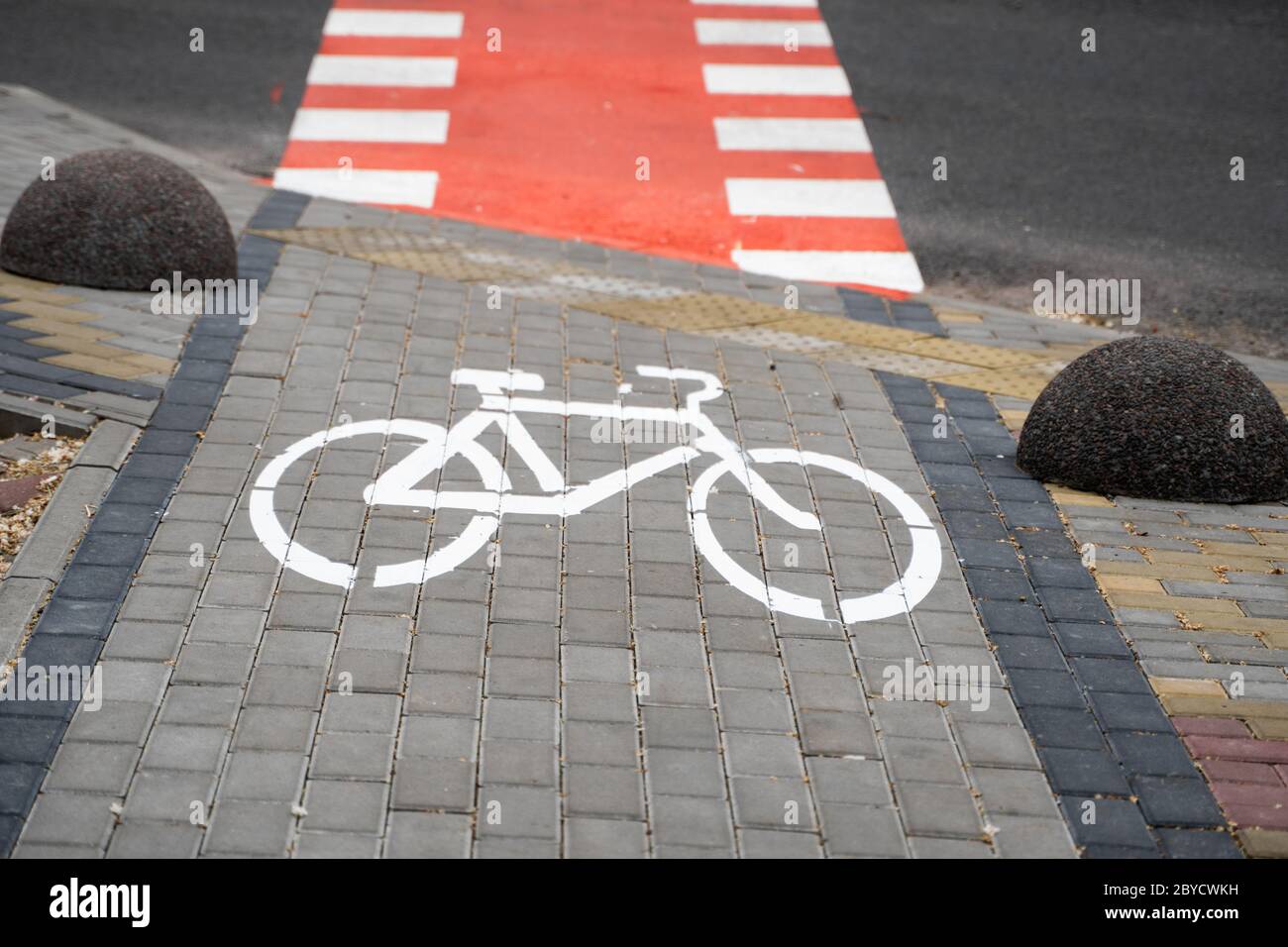 Cycling path with a symbol of bike on a ground through avtomobile road ...