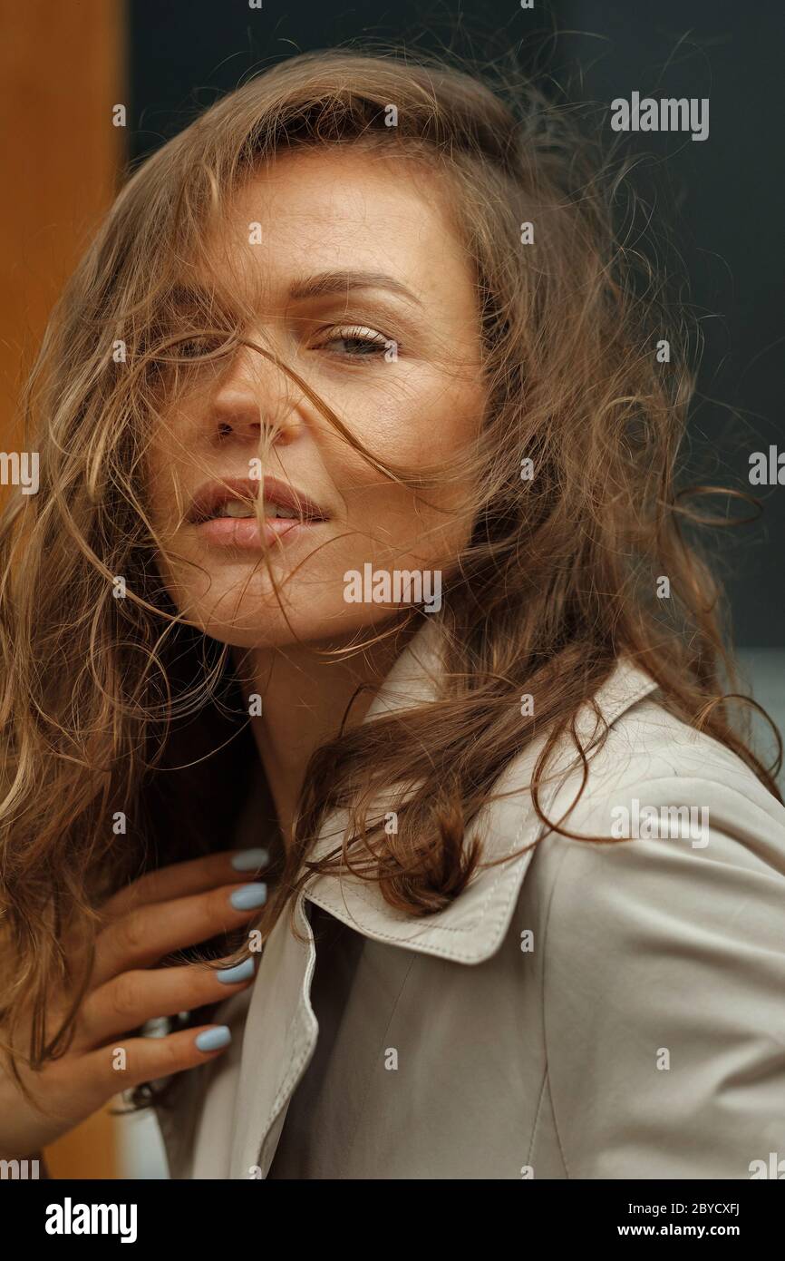 Closeup portrait of pretty lady with hairstyle spoiled by the wind ...