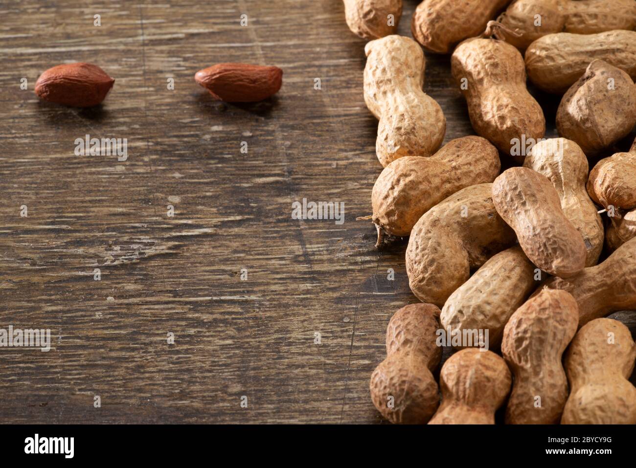 A row of peanuts in the shell making border on a brown background, Top ...