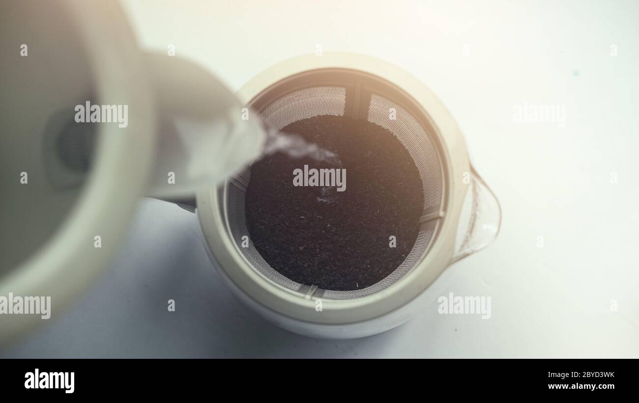 Top view of tea kettle pouring water over brewing tea Stock Photo - Alamy