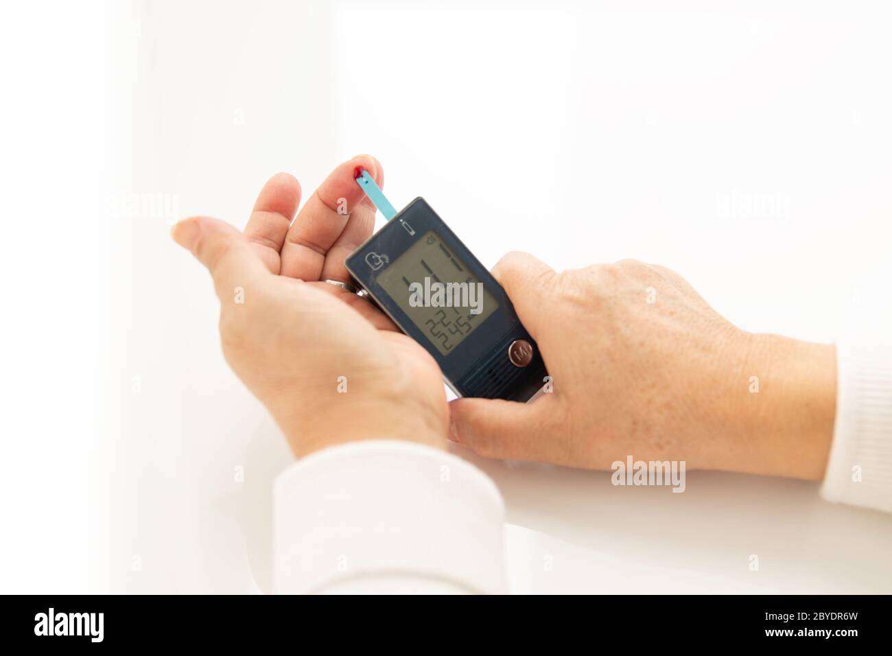 Hands of a person, woman or man self checking her, his diabetes and ...