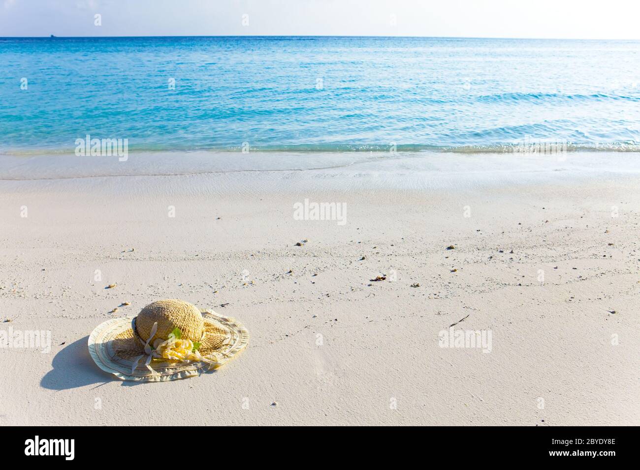 Straw hat lay on sand at edge of sea Stock Photo - Alamy