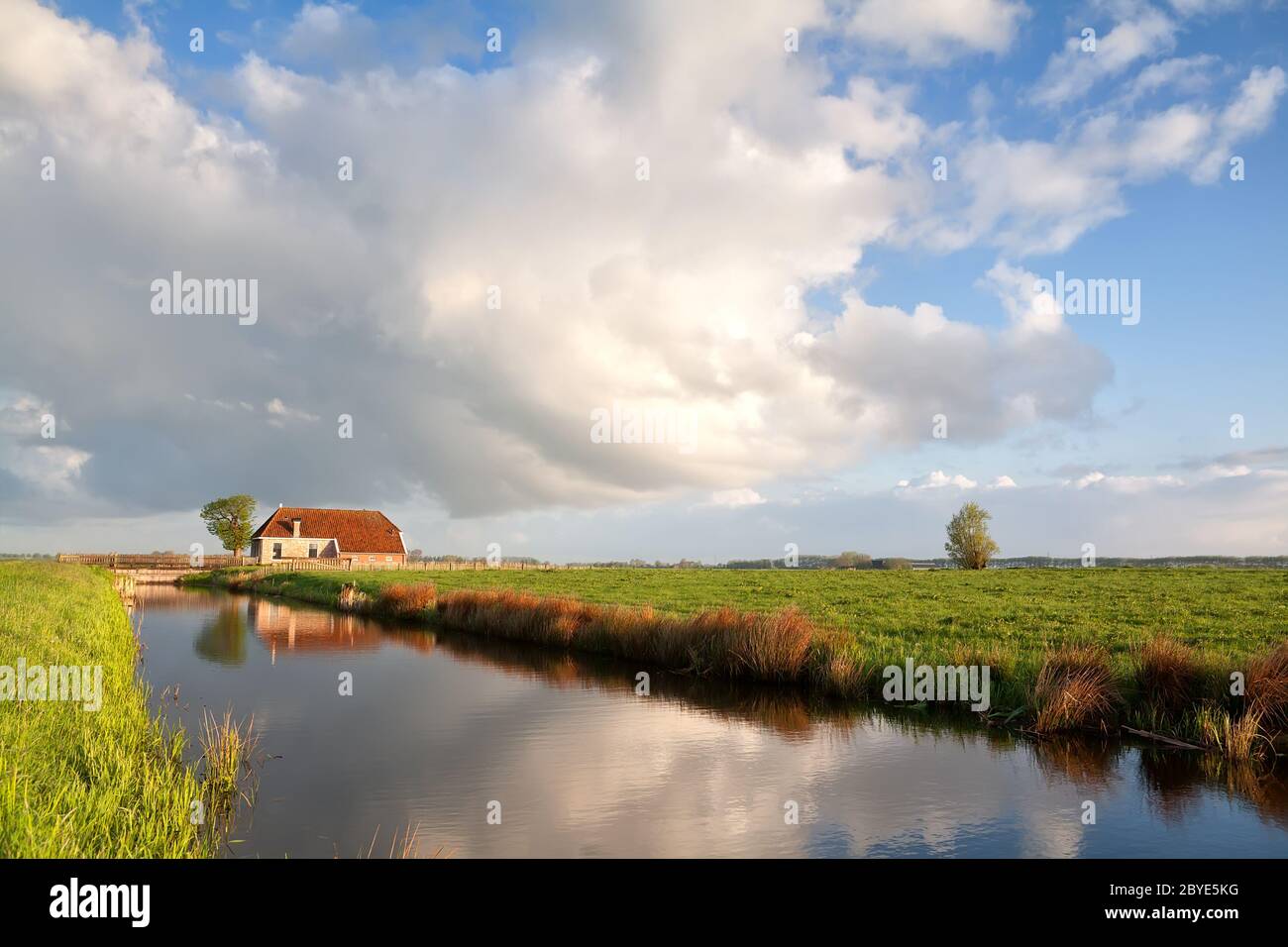 cozy farmhouse by river in morning light Stock Photo - Alamy