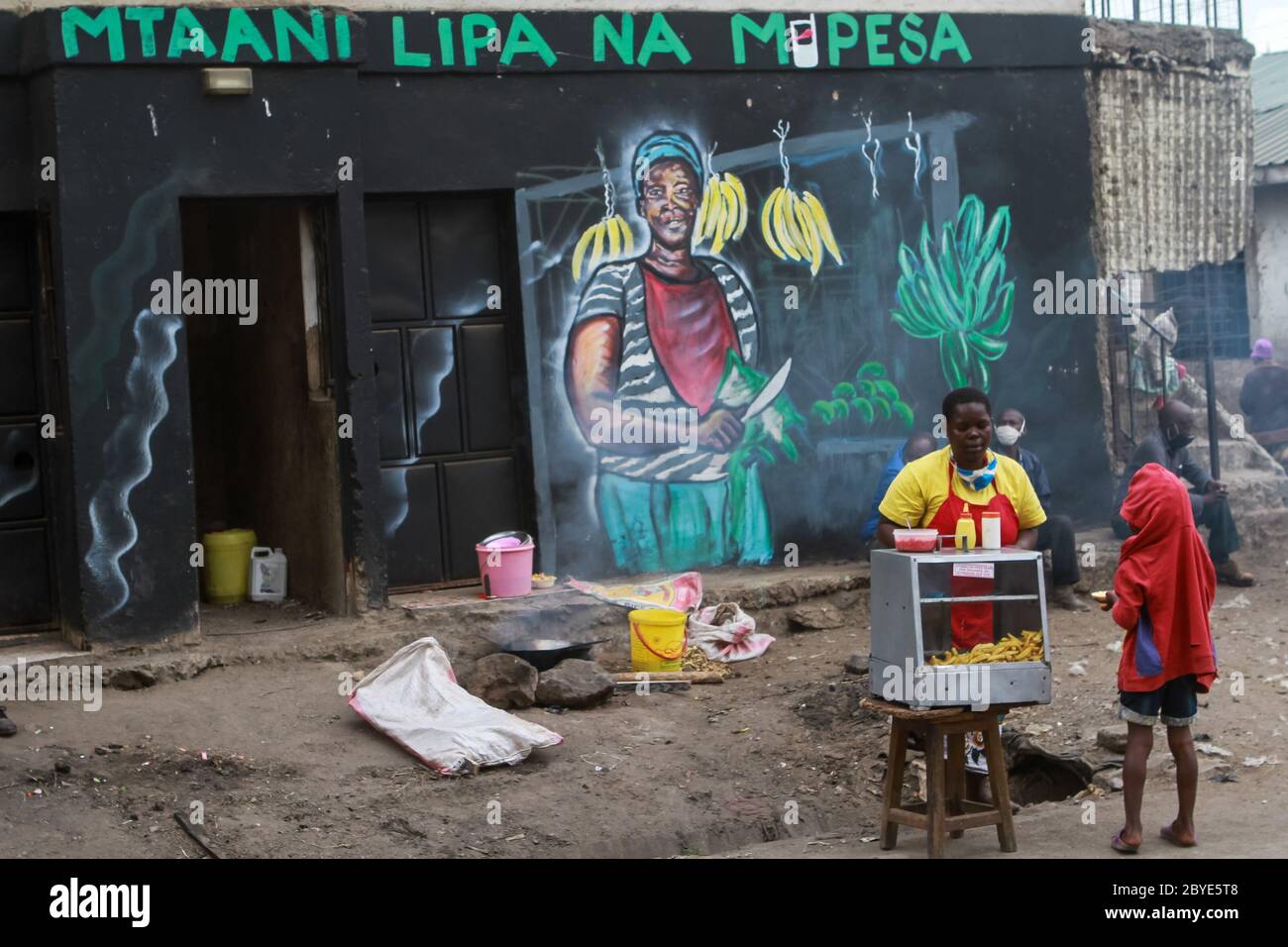 A woman selling potato fries next to a mural depicting a grocery lady ...