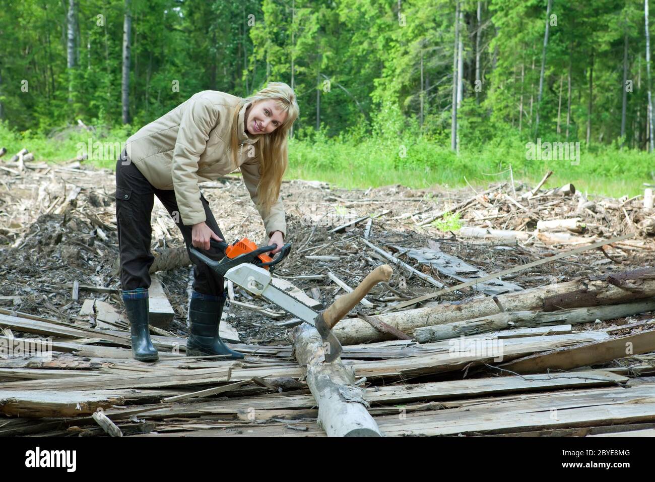 The young woman in wood saws a tree a chain saw Stock Photo - Alamy