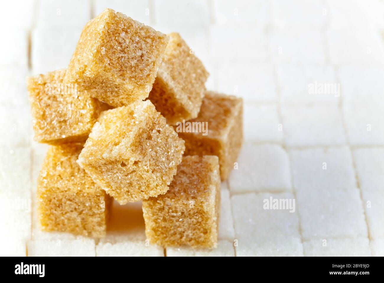 Cubes of not refined reed sugar lie on pieces of w Stock Photo - Alamy