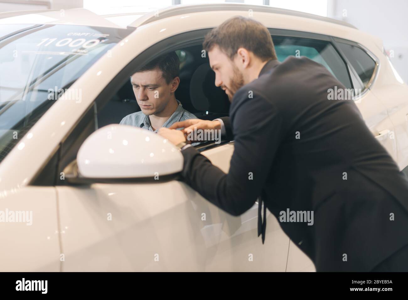 Handsome young man testing of new car in auto dealership Stock Photo ...