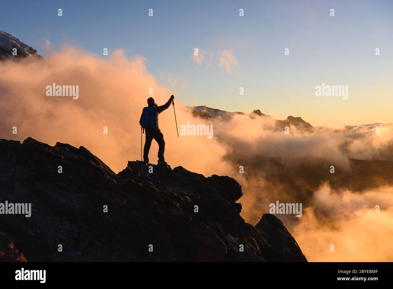Inspiration theme of man standing on top of a cliff with rolling clould ...