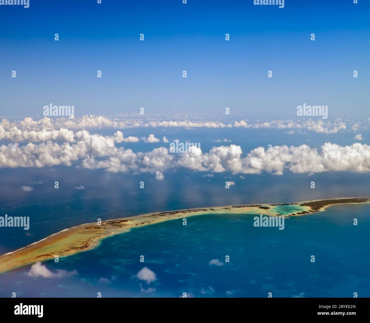 The atoll ring in ocean is visible through clouds Stock Photo - Alamy