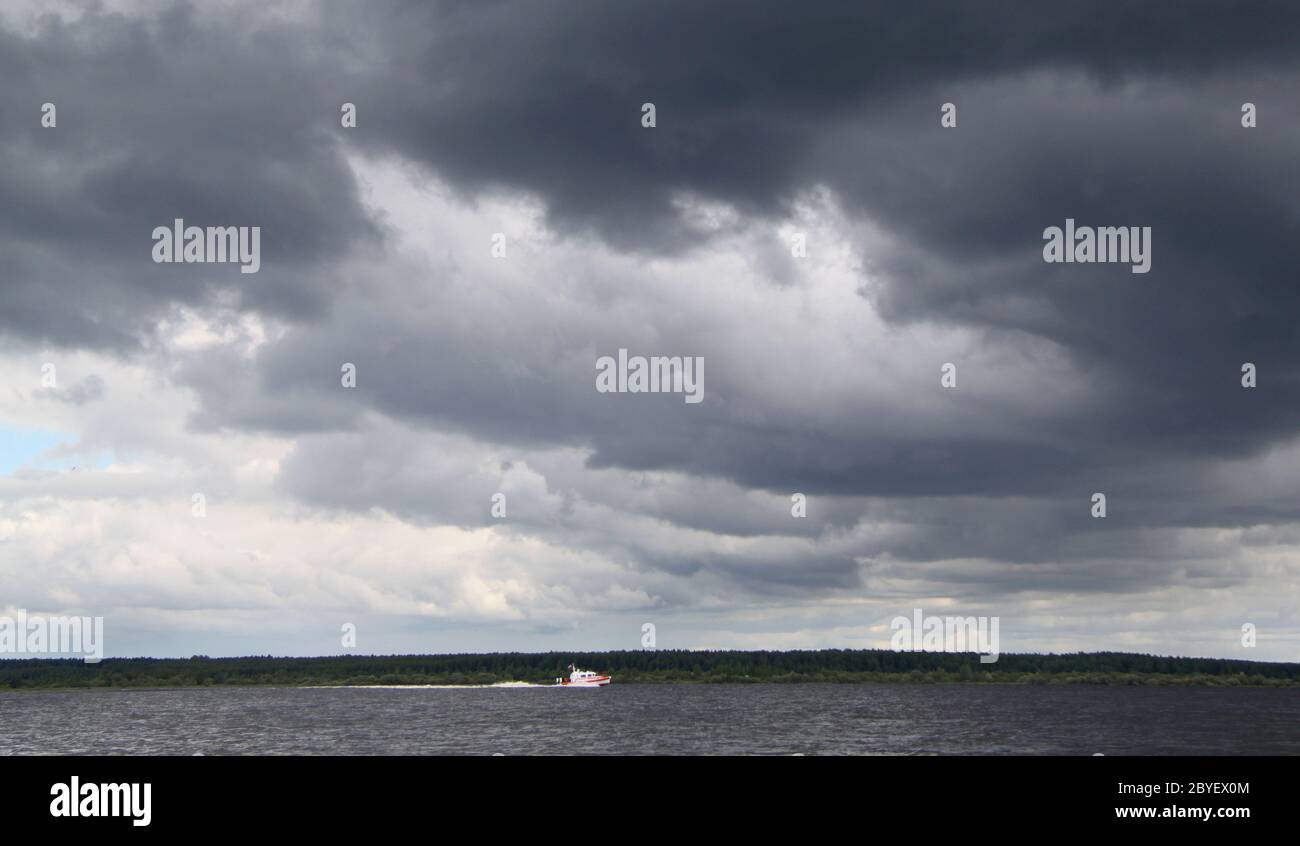 Dark clouds over the river Stock Photo - Alamy