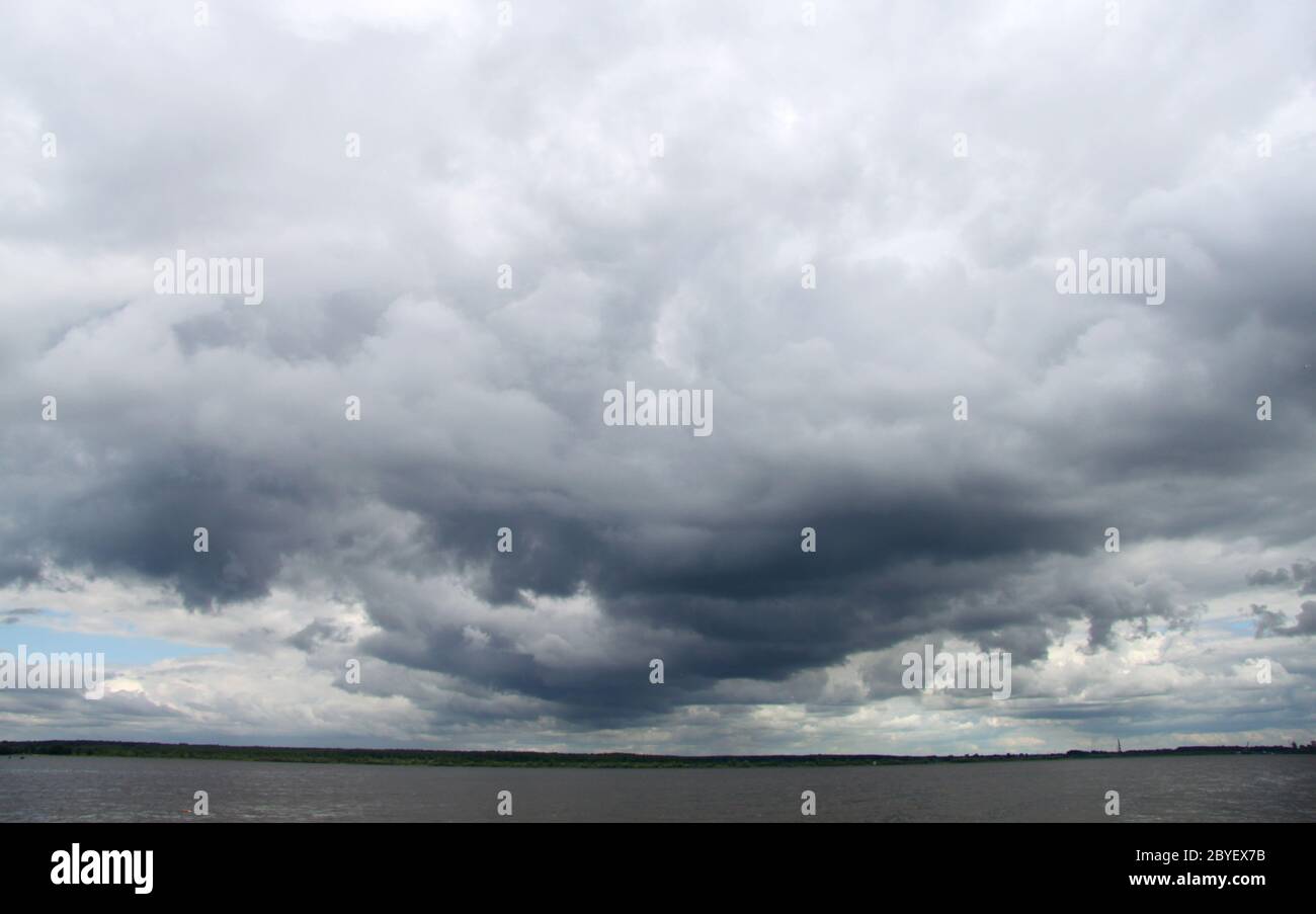 Dark clouds over the river Stock Photo - Alamy