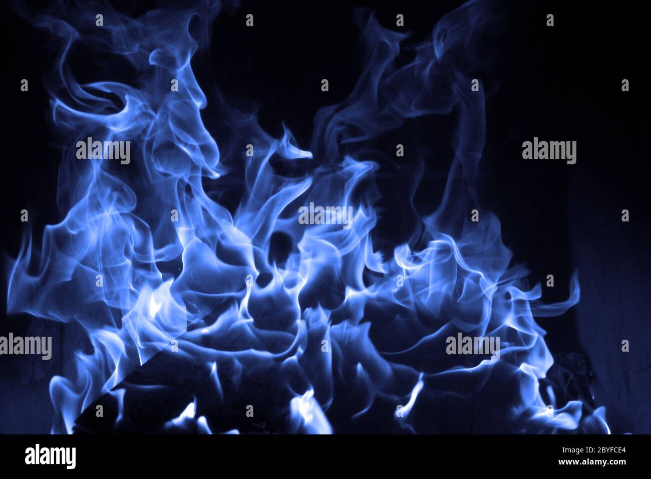 Blue fire on black background Stock Photo - Alamy