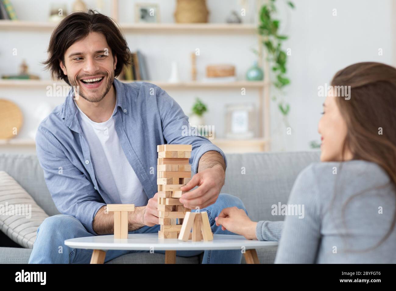 Funny guy playing Jenga with girlfriend at home Stock Photo - Alamy