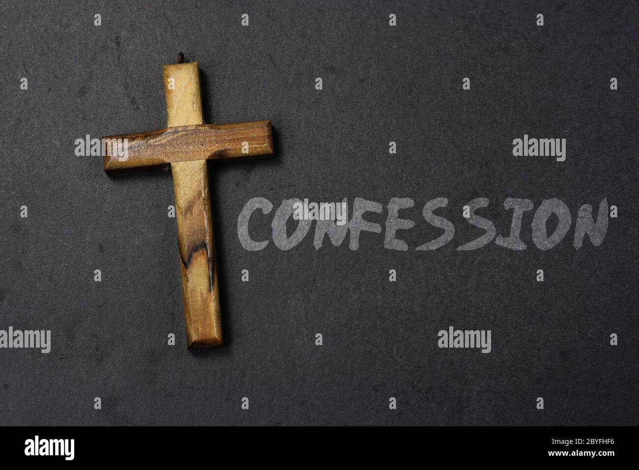 Confession word written on black background with wooden cross ...