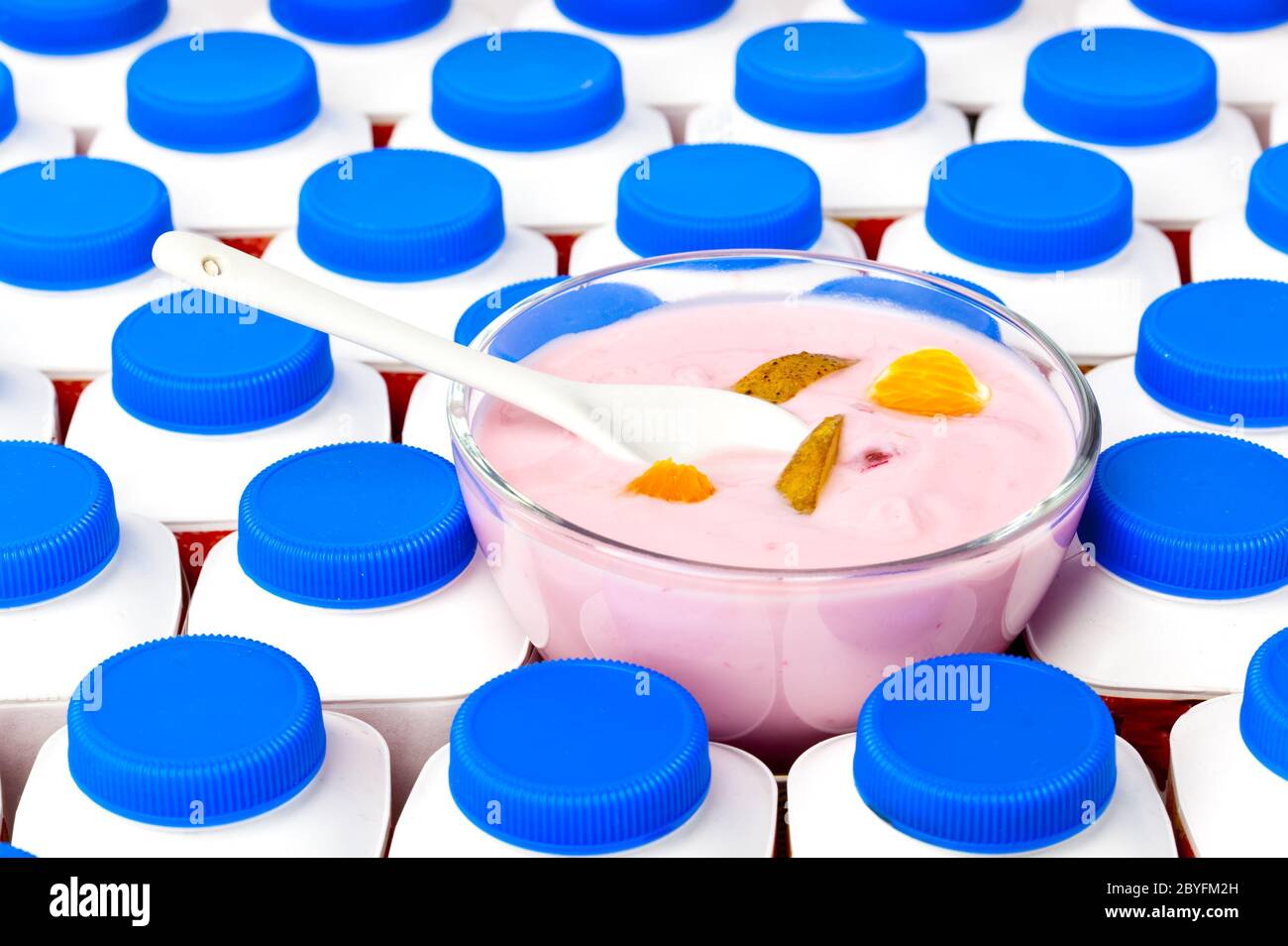 yogurt bottles with dark blue covers And a glass b Stock Photo - Alamy