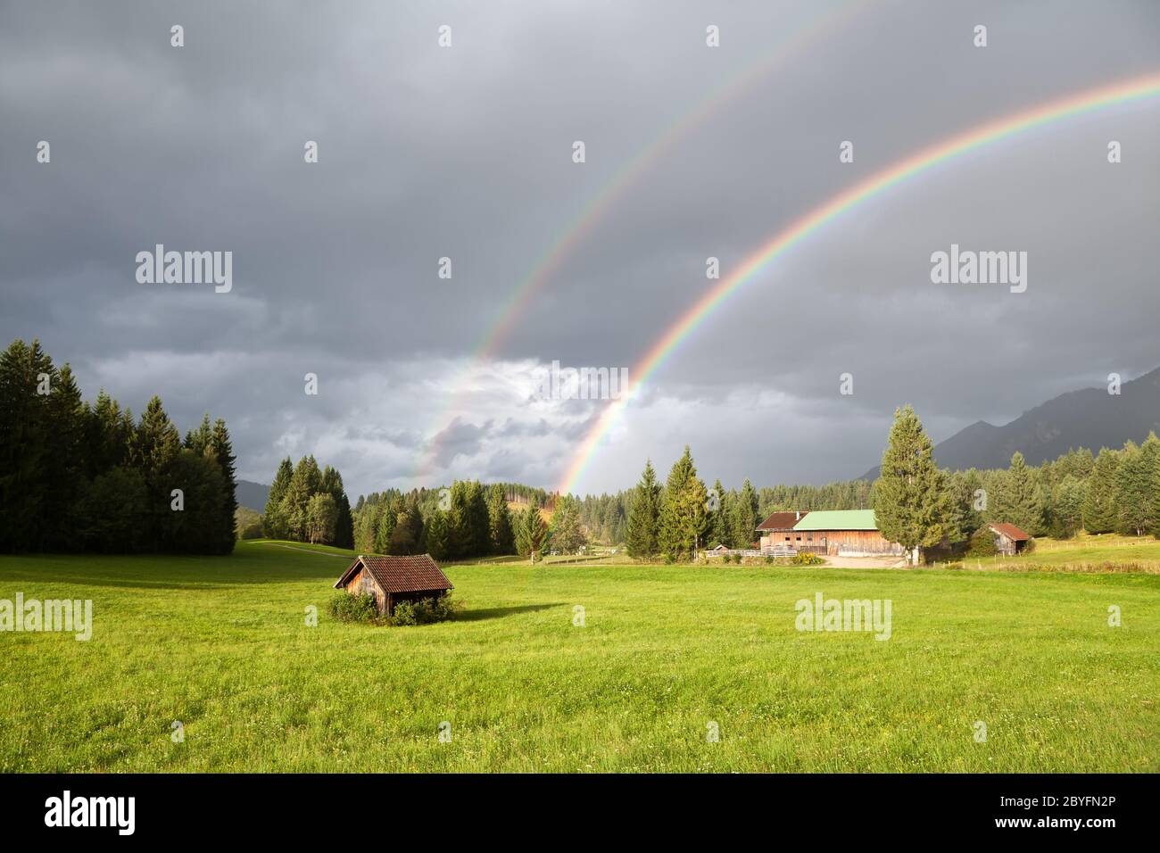 colorful rainbow during rain in Alps Stock Photo - Alamy
