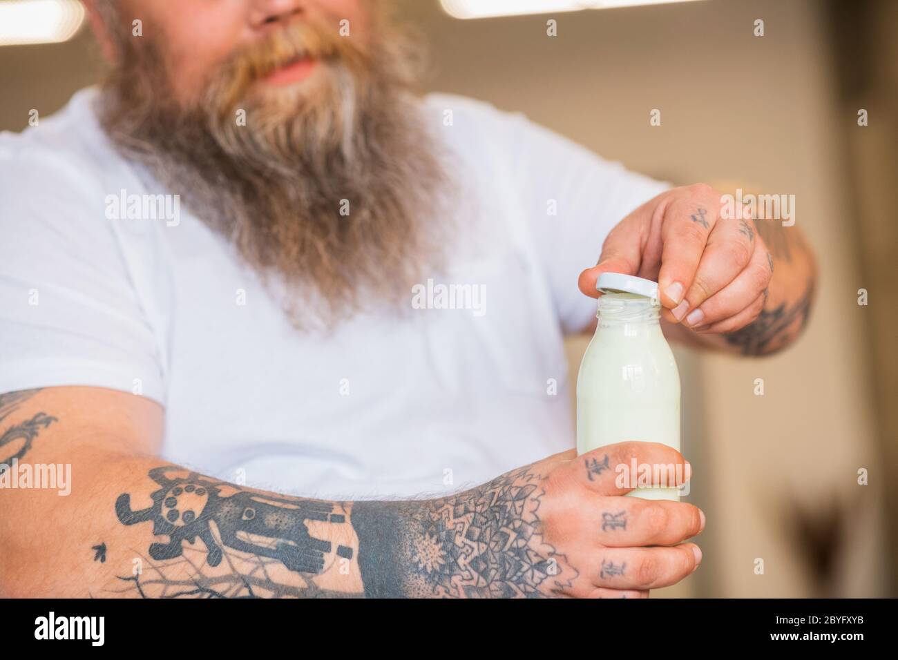 Close up picture of a man opening a bottle with milk Stock Photo - Alamy