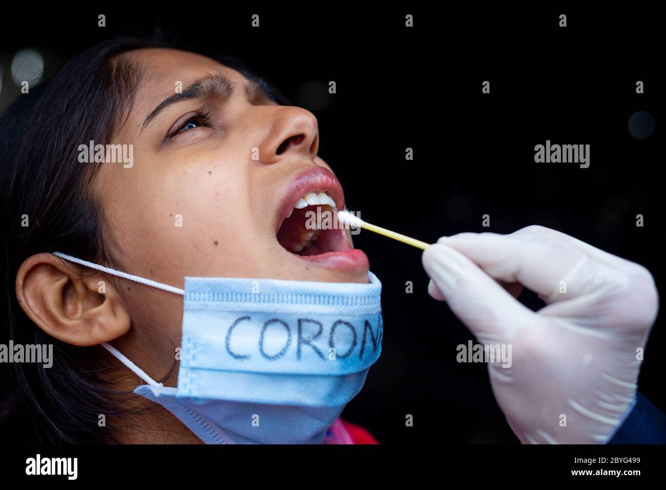 Doctor's hand taking Saliva test from young woman's mouth with Cotton ...