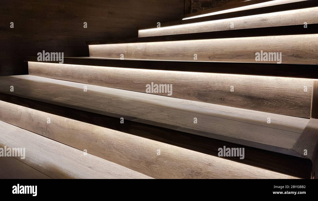 Illuminated staircase with wooden steps and illuminated at night in the ...