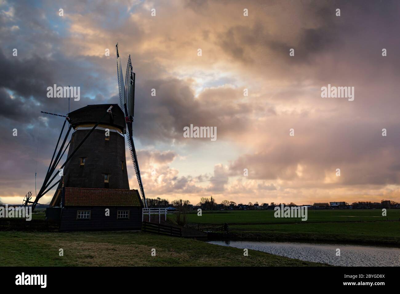 Dutch windmill facing the early rain winds and running the turbine to ...