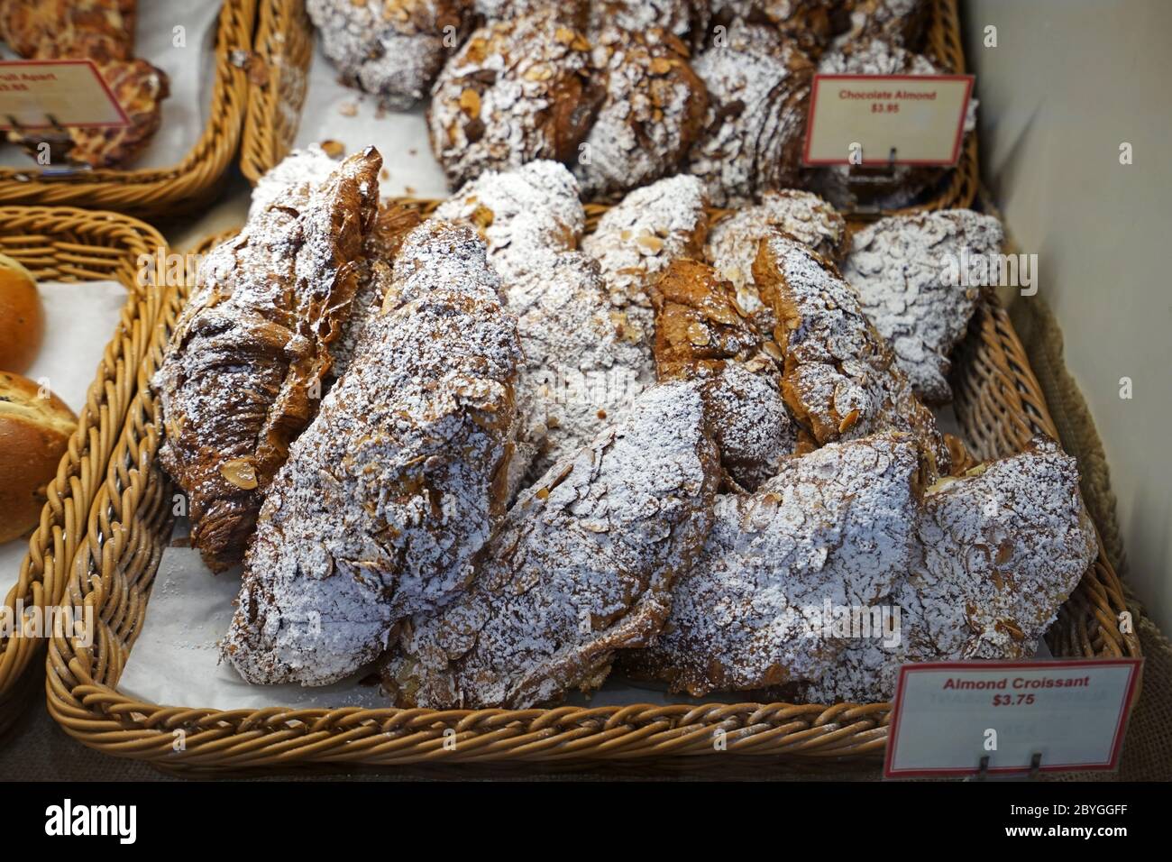 Close up basket of almond and butter croissant in display showcase box ...