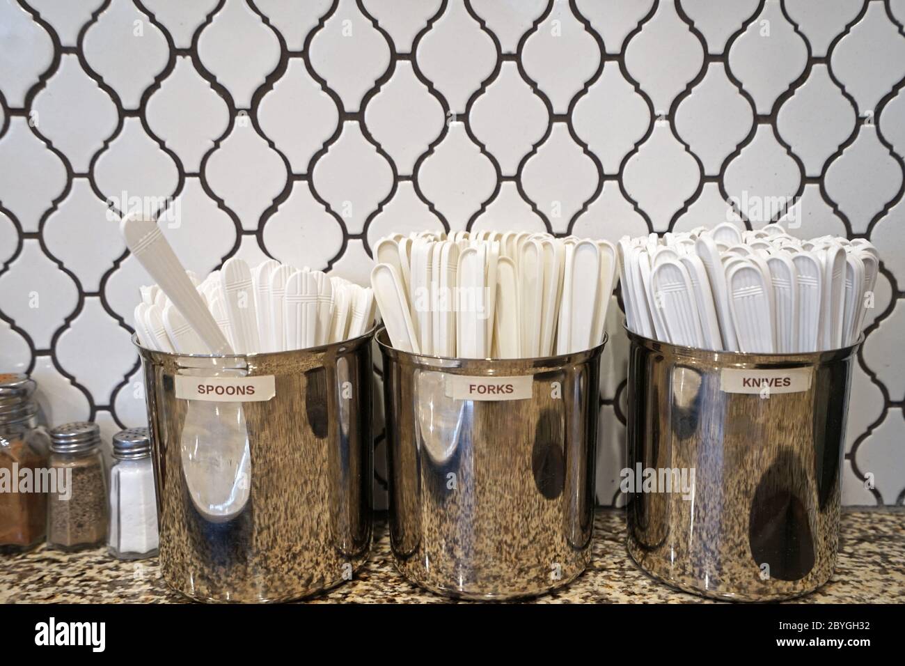 Plastic cutlery station with white Moroccan wall tiles Stock Photo - Alamy