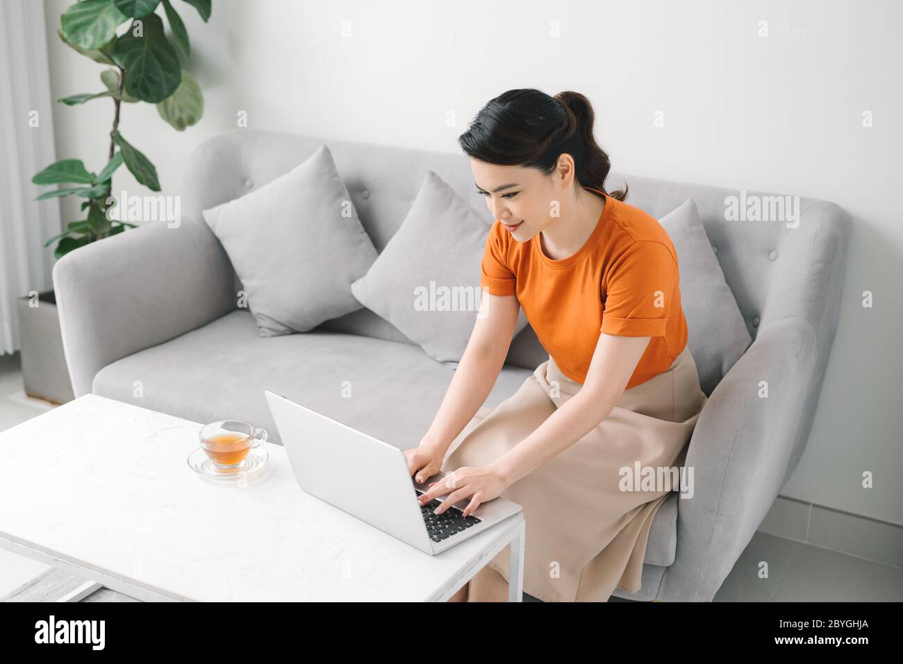 Happy girl browsing through the internet during free time at home Stock ...
