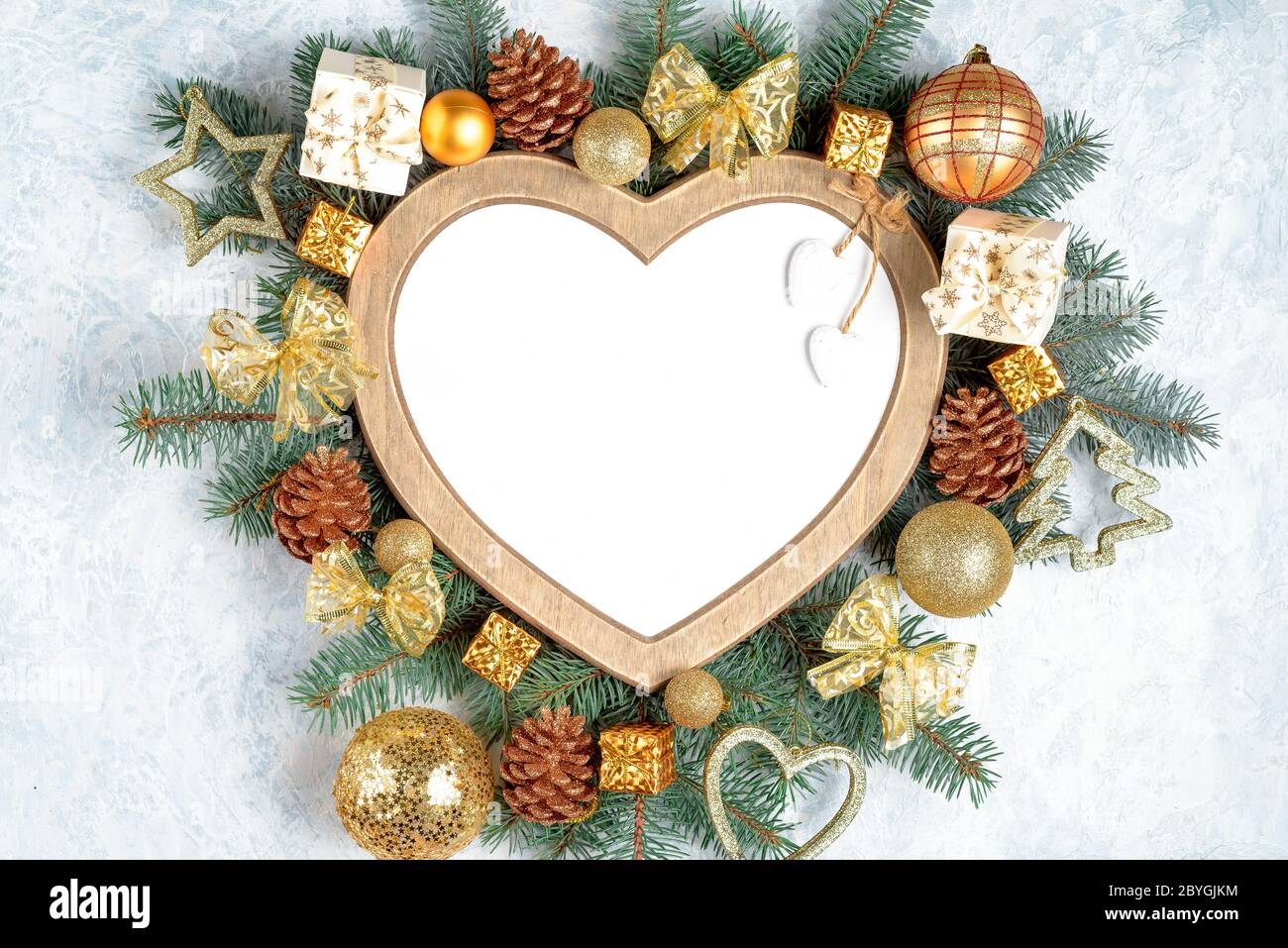 Christmas frame in the shape of a heart is surrounded by branches of a ...