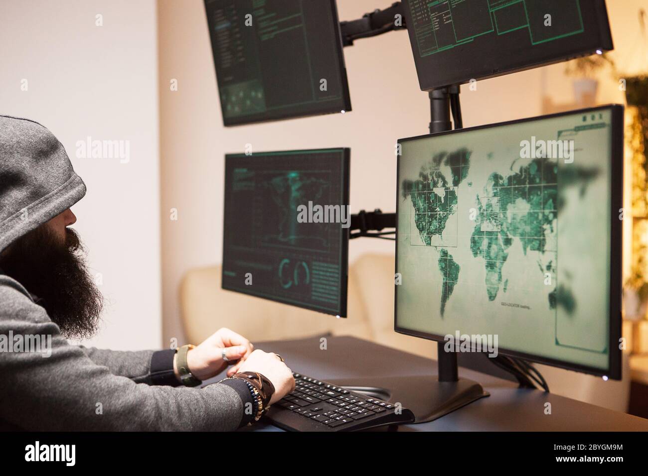 International hacker wearing a hoodie while doing a cyber attack with ...