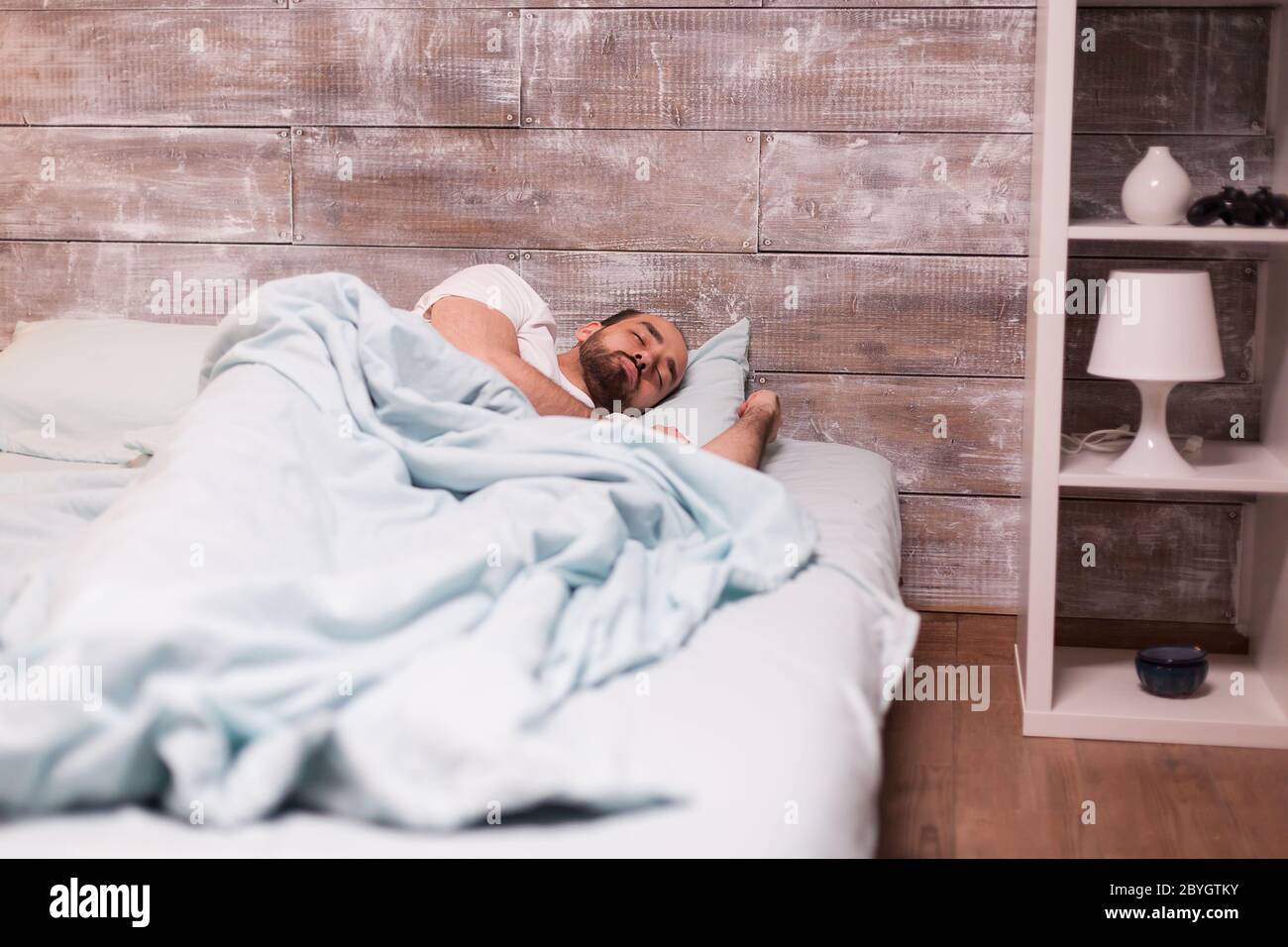 Man sleeping alone in his comfortable bed with peaceful face Stock ...