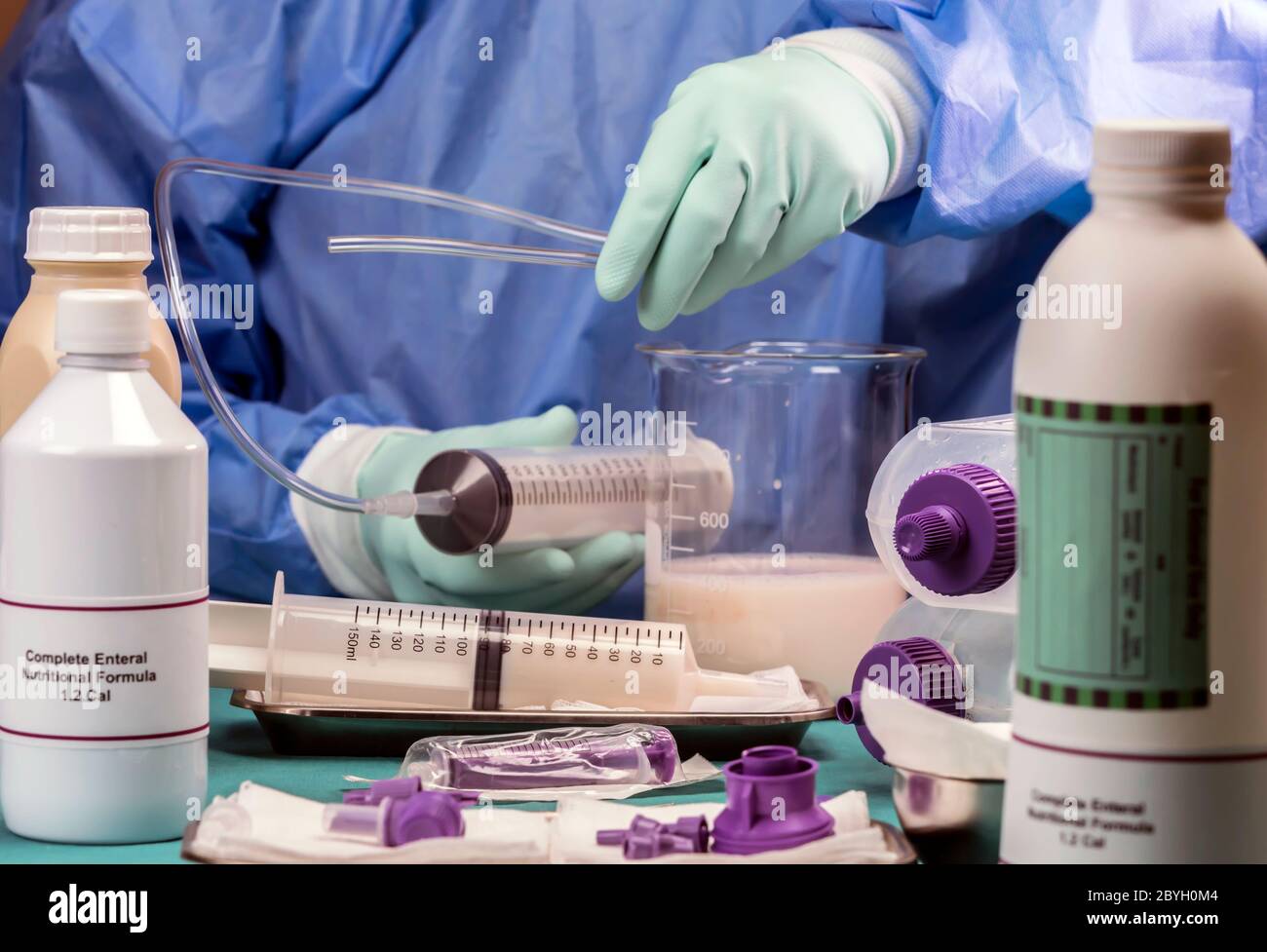 Nurse extracts enteral nutrition content with syringe, pailative care ...