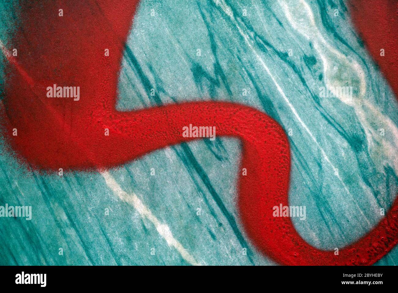 A Close Up Of Red Spray Painted Graffiti On A Green Marble Wall Stock ...