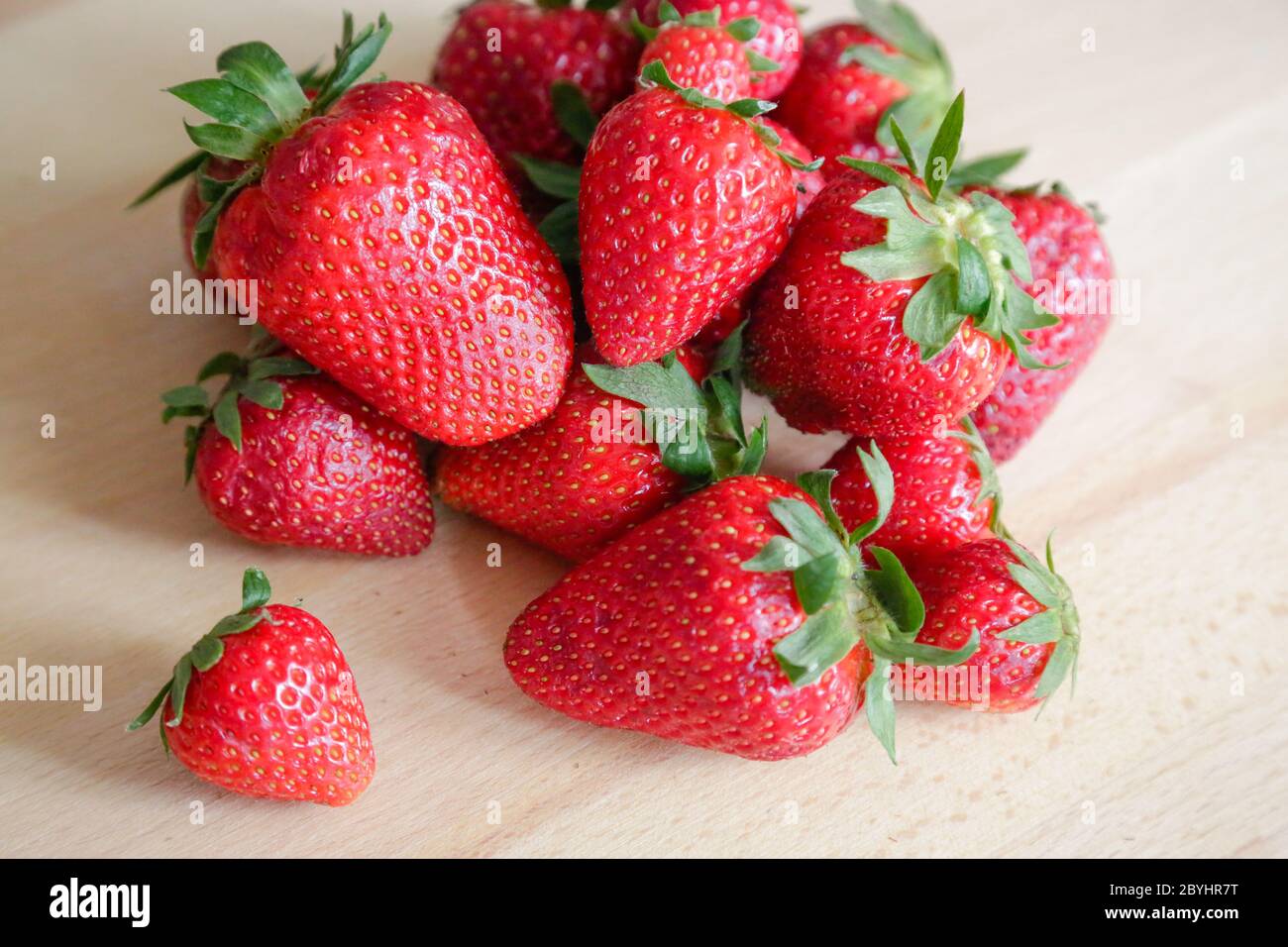 Strawberries on wooden table, natural light Stock Photo - Alamy