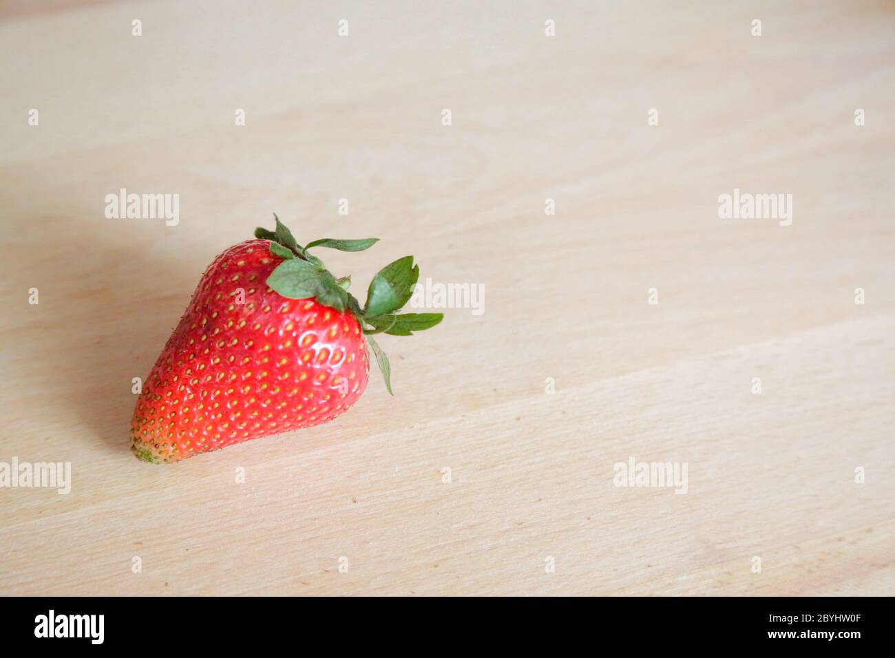 Strawberries on wooden table, natural light Stock Photo - Alamy