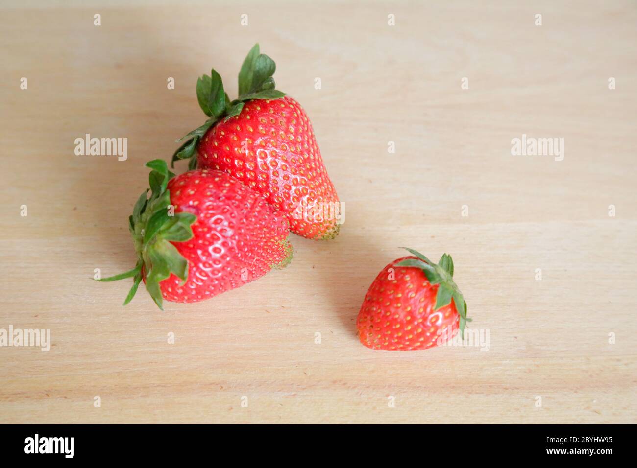 Strawberries on wooden table, natural light Stock Photo - Alamy