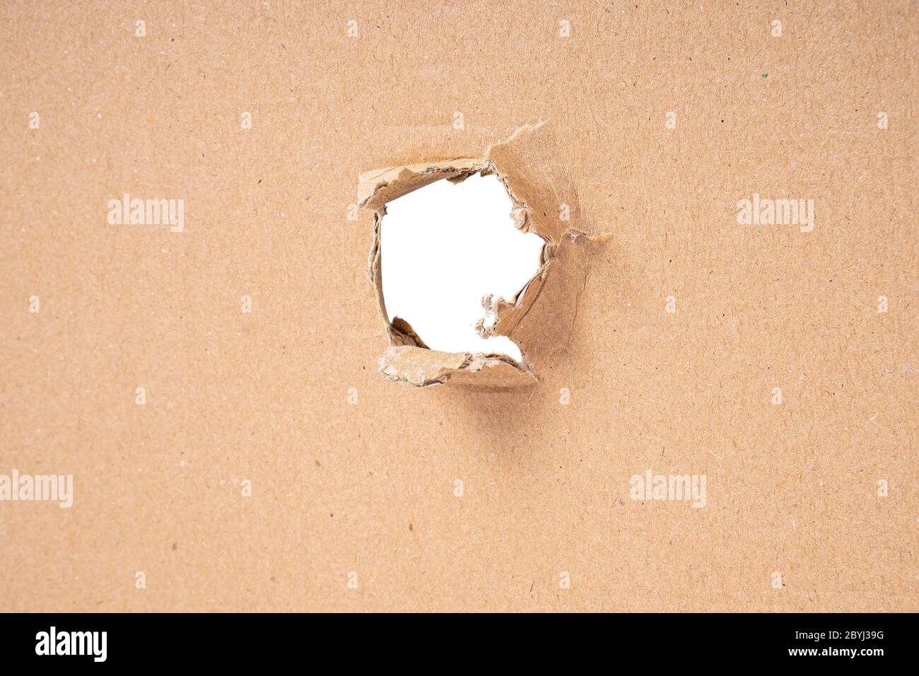 Ripped hole in cardboard on white background Stock Photo - Alamy
