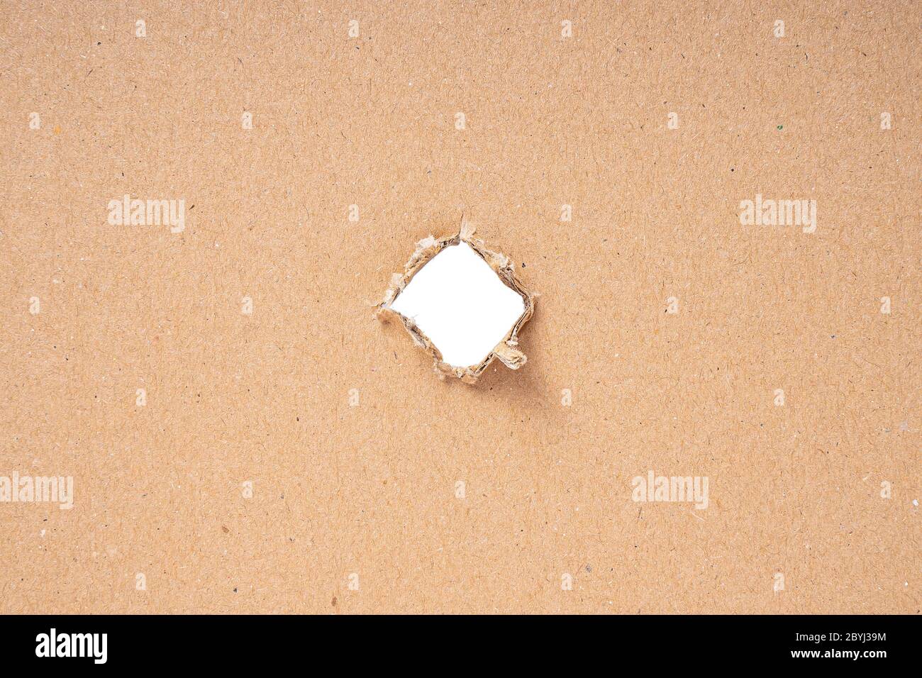 Ripped hole in cardboard on white background Stock Photo - Alamy